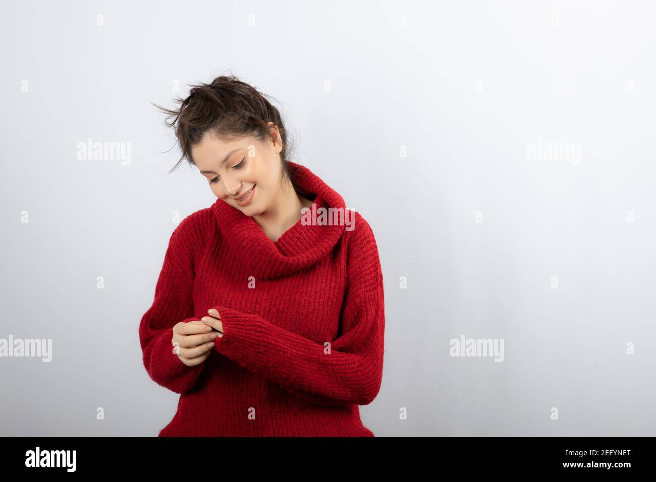 Photo of a pretty young woman in warm red sweater posing Stock Photo ...