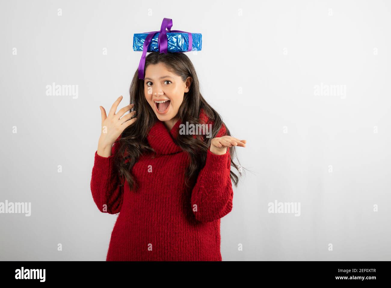 Portrait of a happy girl putting a gift box on her head Stock Photo - Alamy