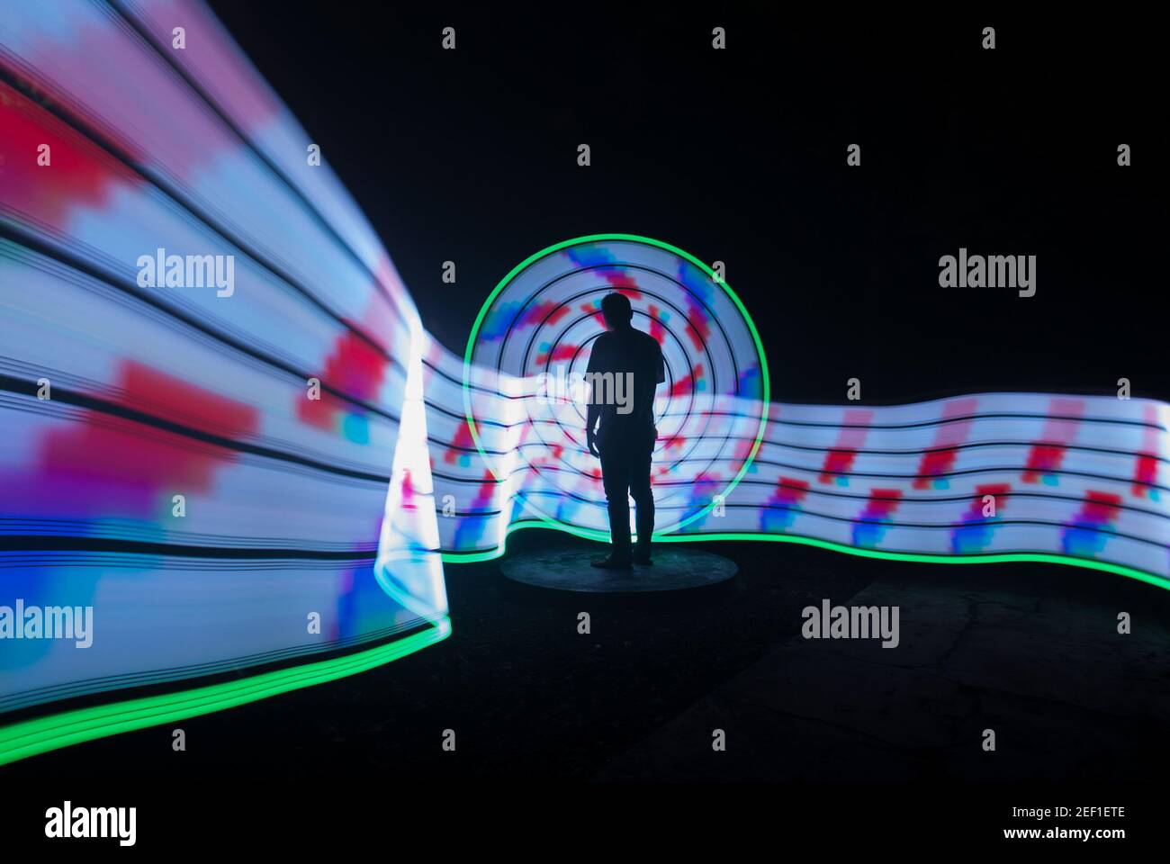 One person standing alone against beautiful color circle LED light ... One person standing alone against beautiful color circle LED light ...