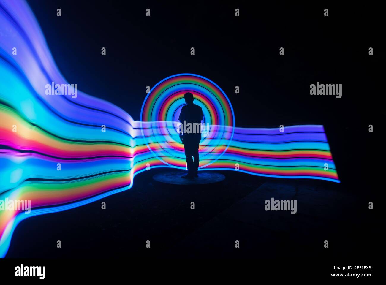 One person standing alone against beautiful color circle LED light ...