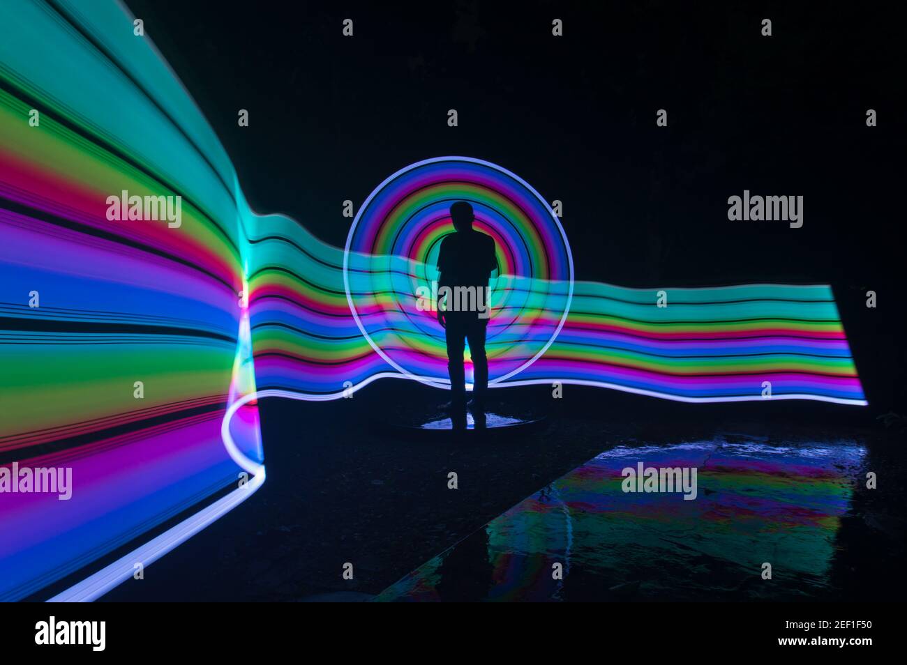 One person standing alone against beautiful color circle LED light ...
