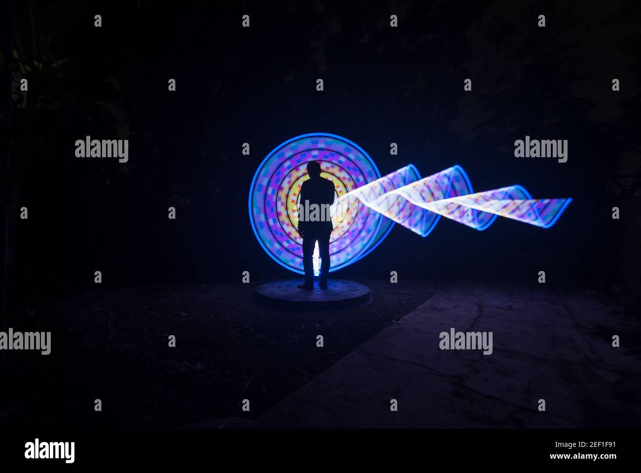 One person standing alone against beautiful color circle LED light ...