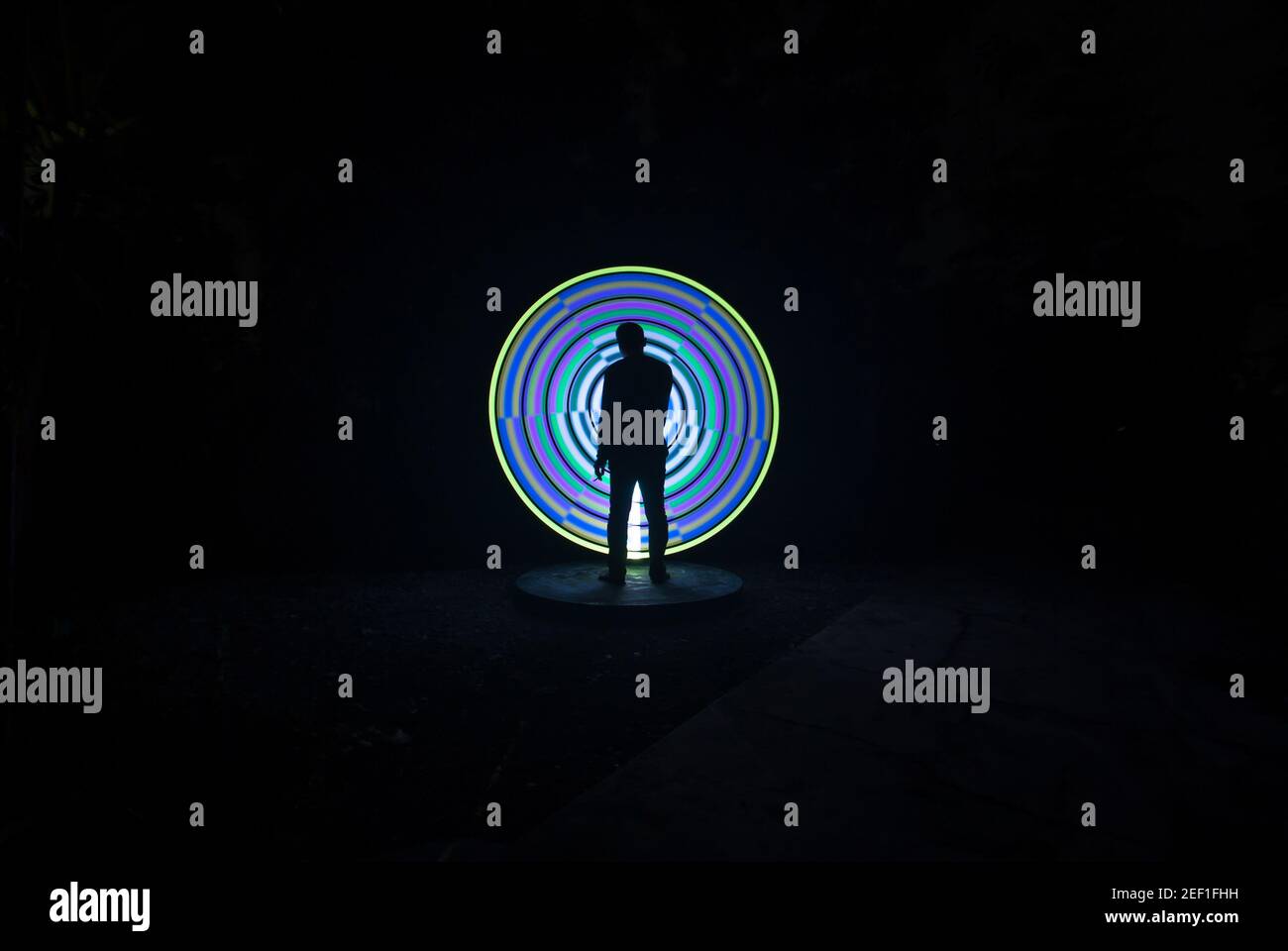 One person standing alone against beautiful color circle LED light ... One person standing alone against beautiful color circle LED light ...