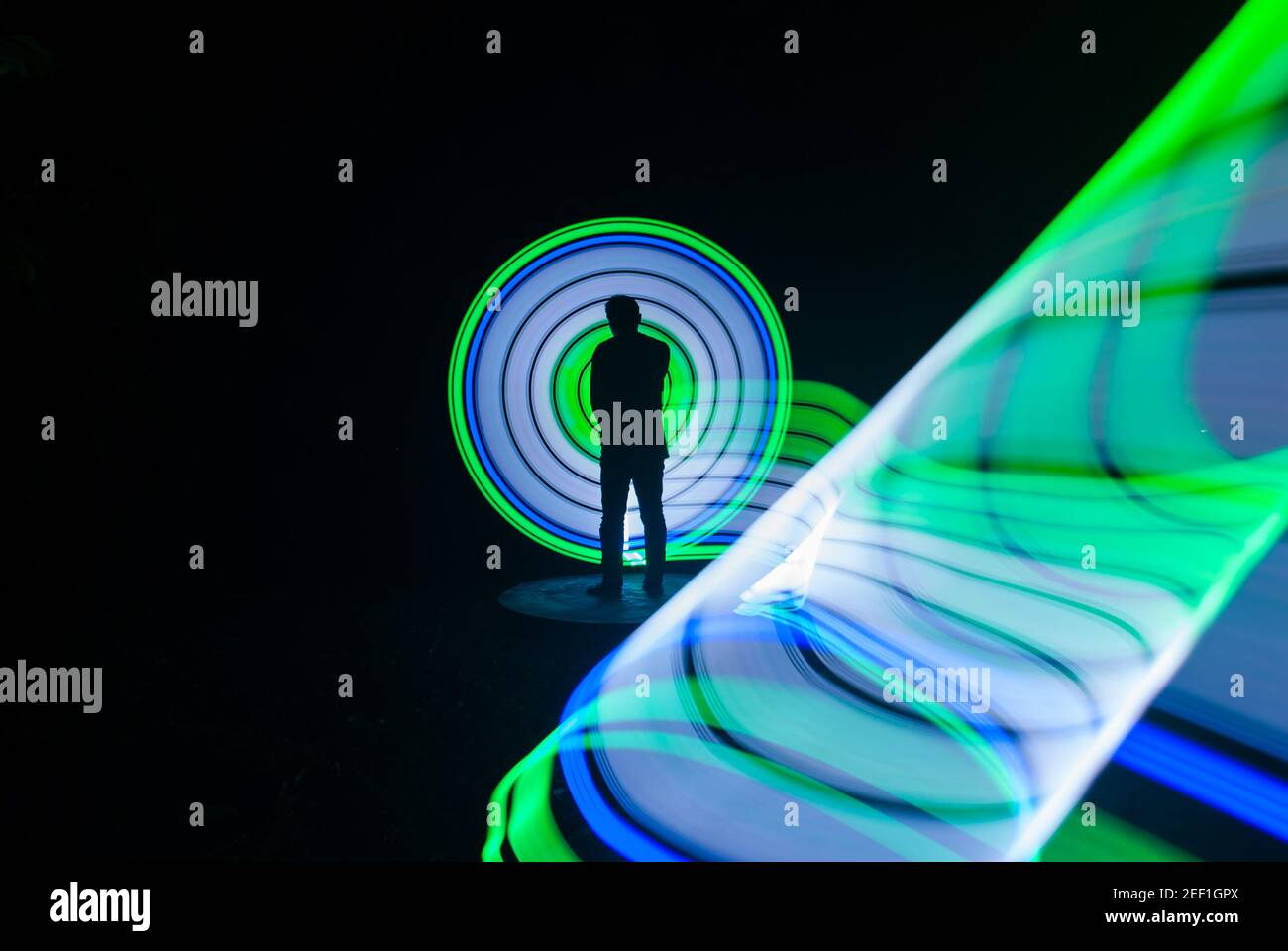 One person standing alone against beautiful color circle LED light ... One person standing alone against beautiful color circle LED light ...
