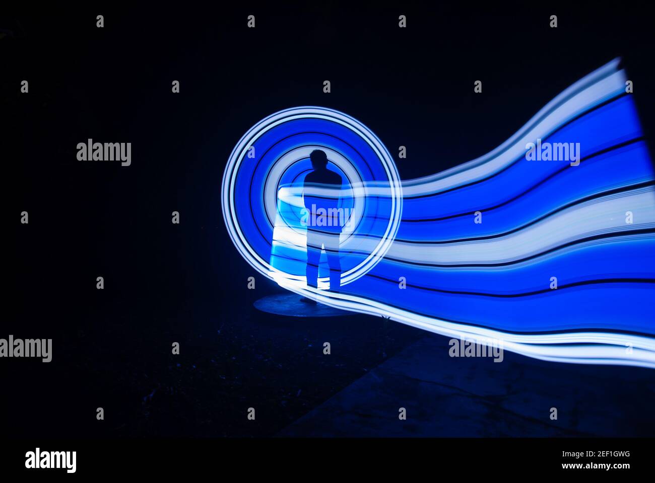 One person standing alone against beautiful color circle LED light ...