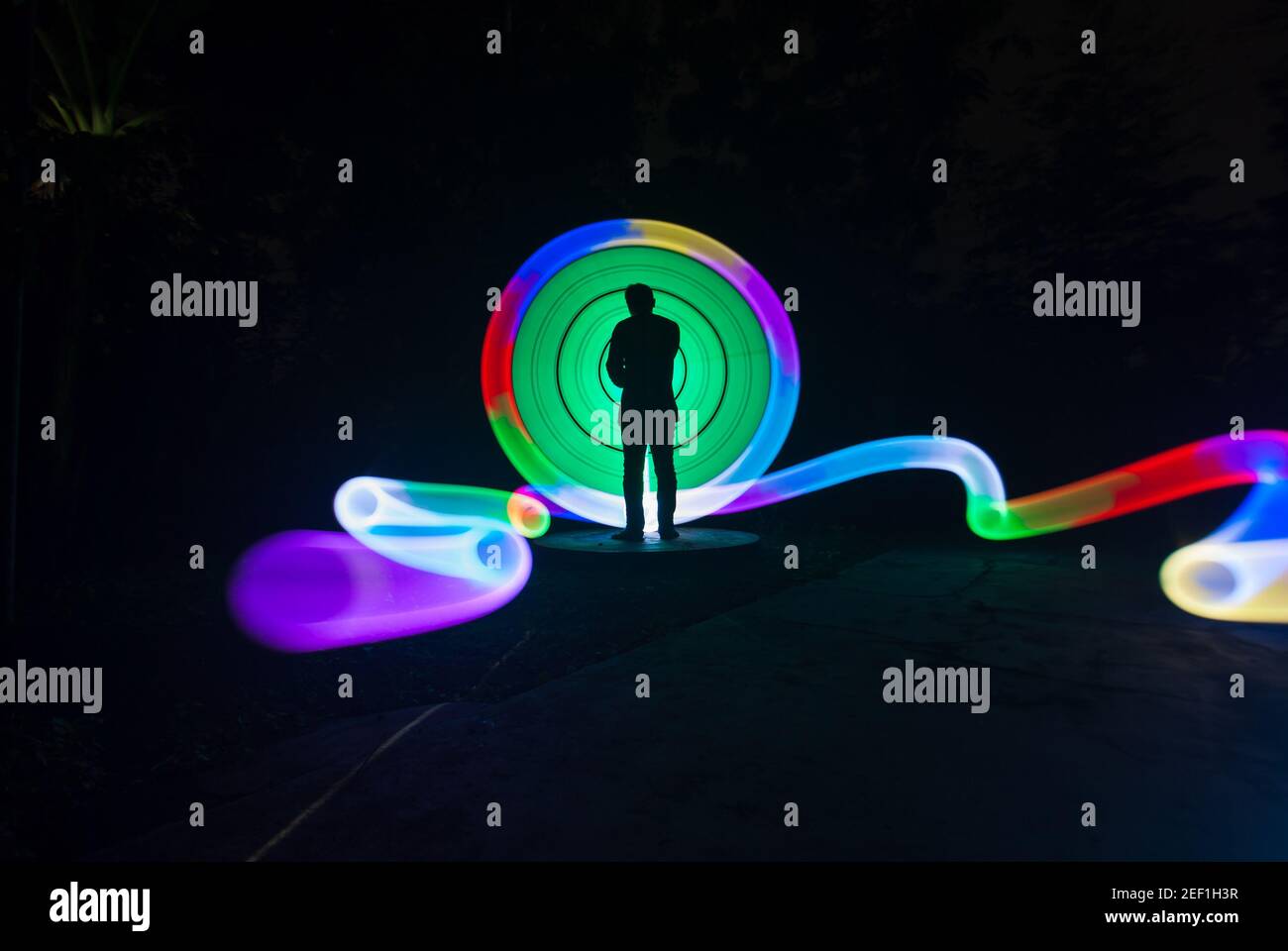 One person standing alone against beautiful color circle LED light ...