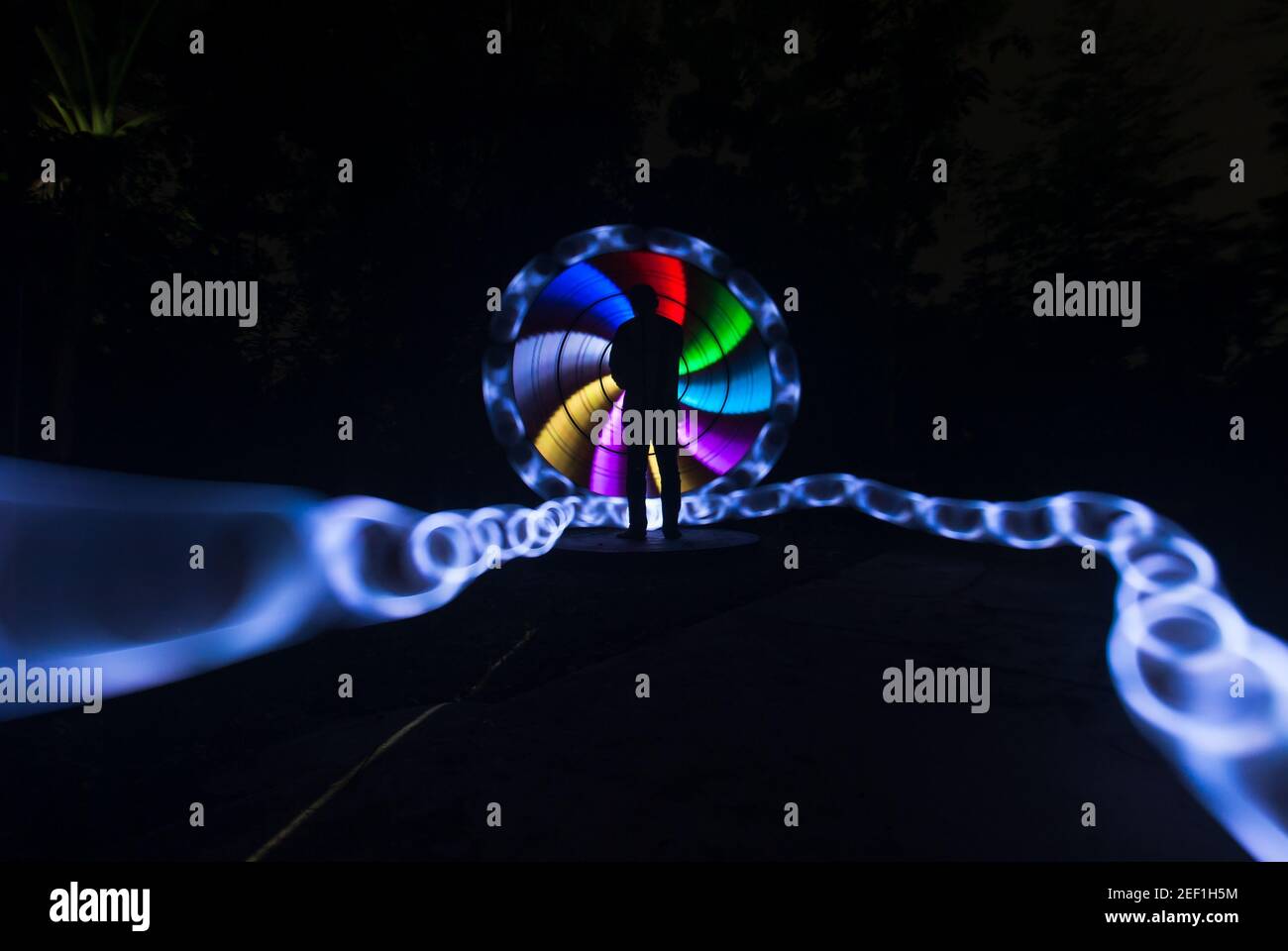 One person standing alone against beautiful color circle LED light ...