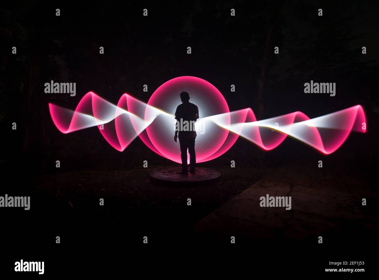 One person standing alone against beautiful color circle LED light ...