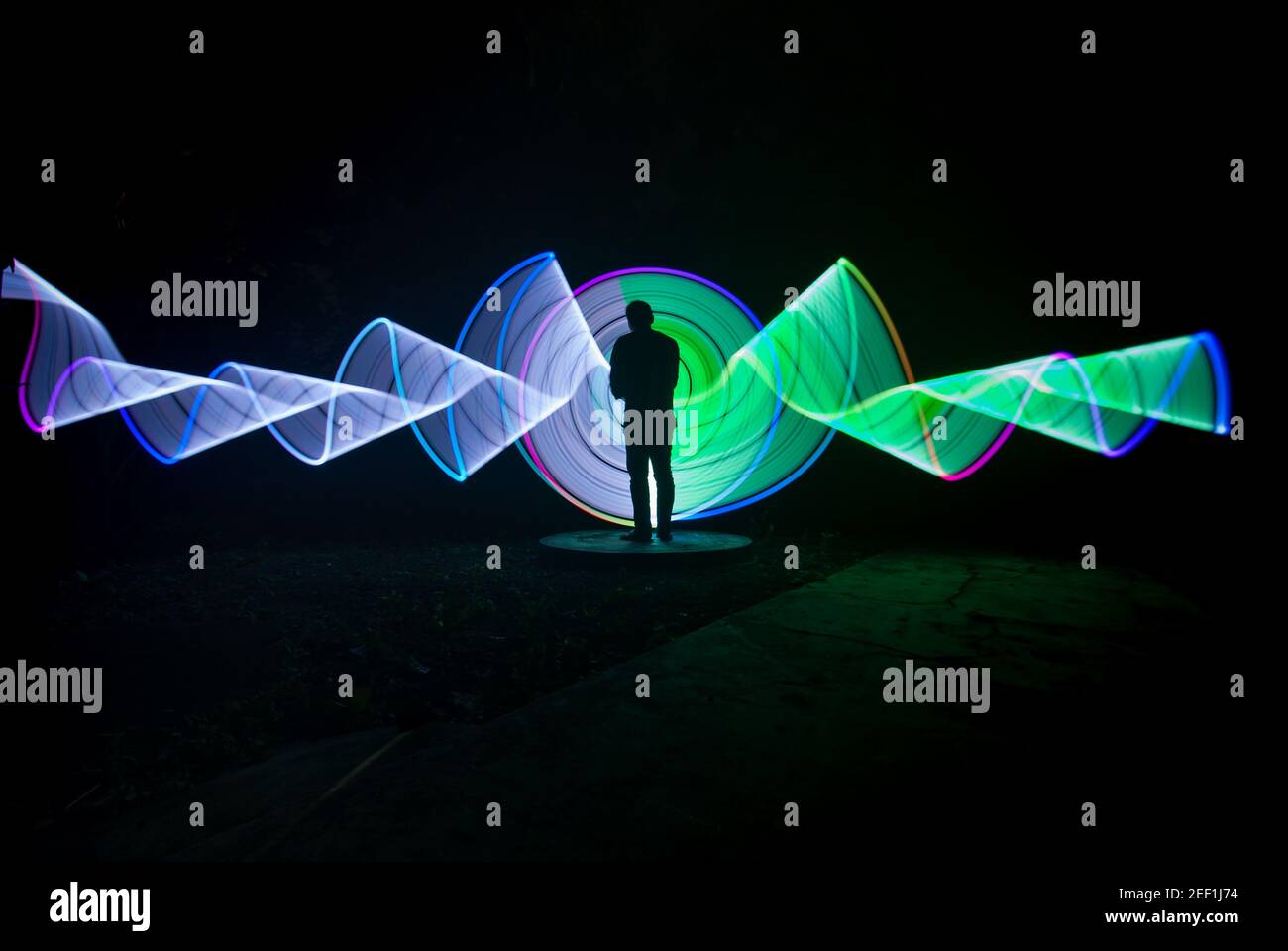 One person standing alone against beautiful color circle LED light ...