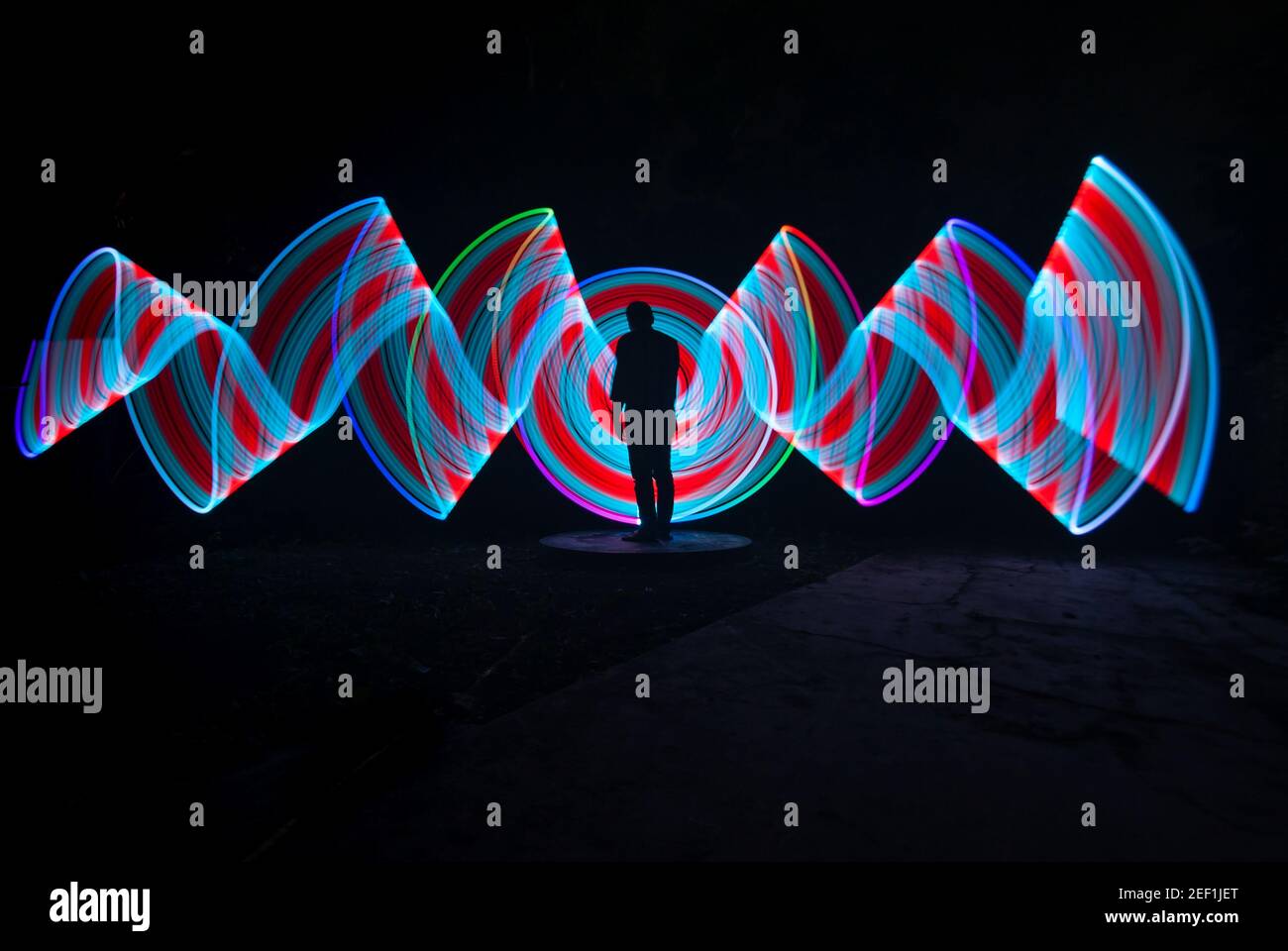 One person standing alone against beautiful color circle LED light ...