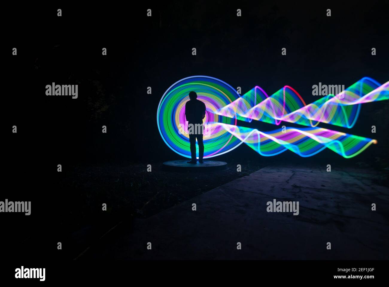 One person standing alone against beautiful color circle LED light ...