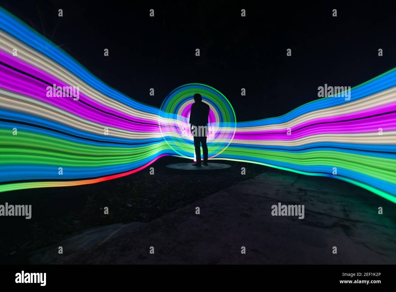 One person standing alone against beautiful color circle LED light ...