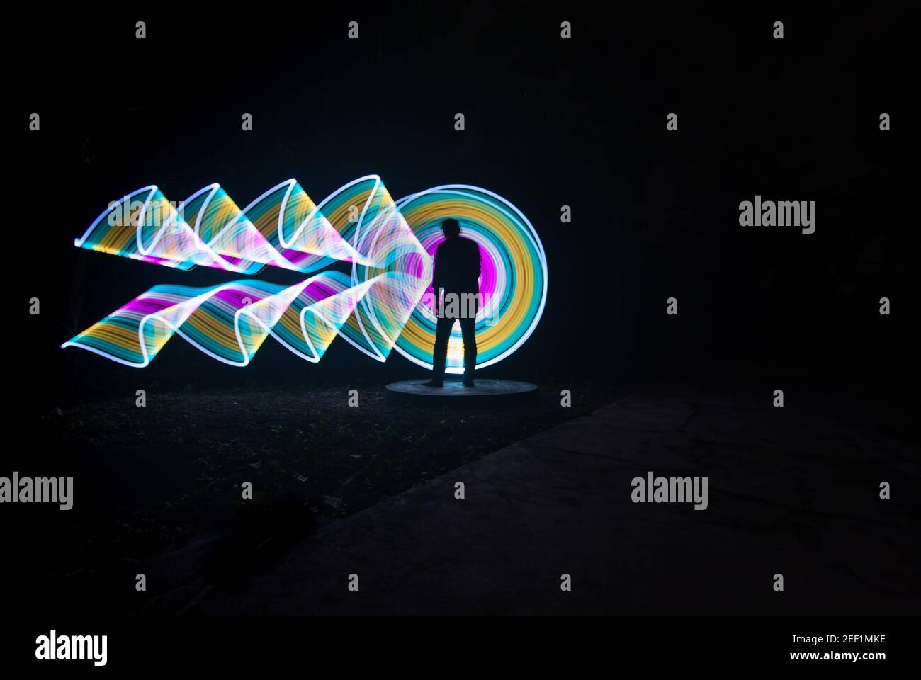 One person standing alone against beautiful color circle LED light ...