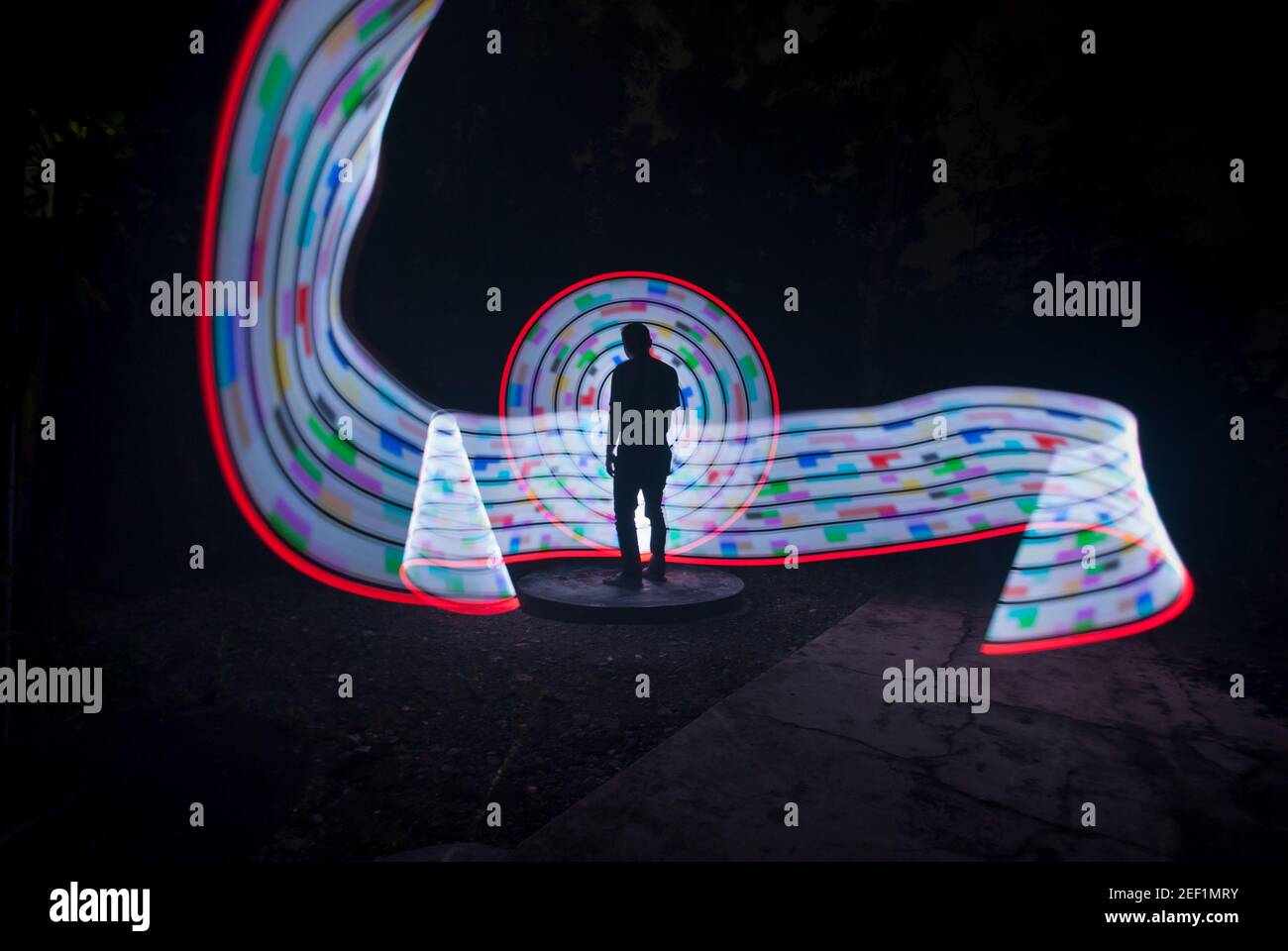 One person standing alone against beautiful color circle LED light ...