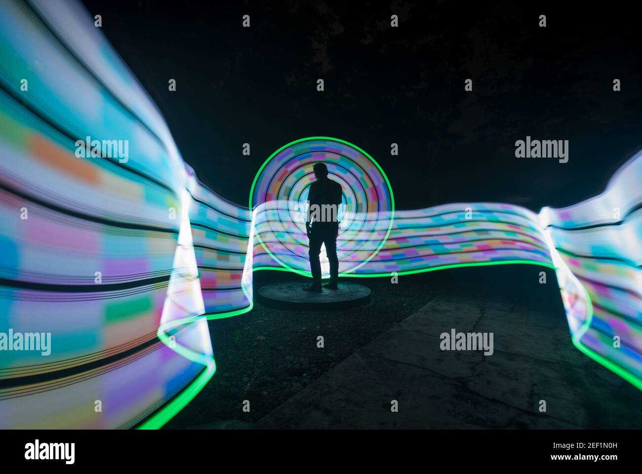 One person standing alone against beautiful color circle LED light ...