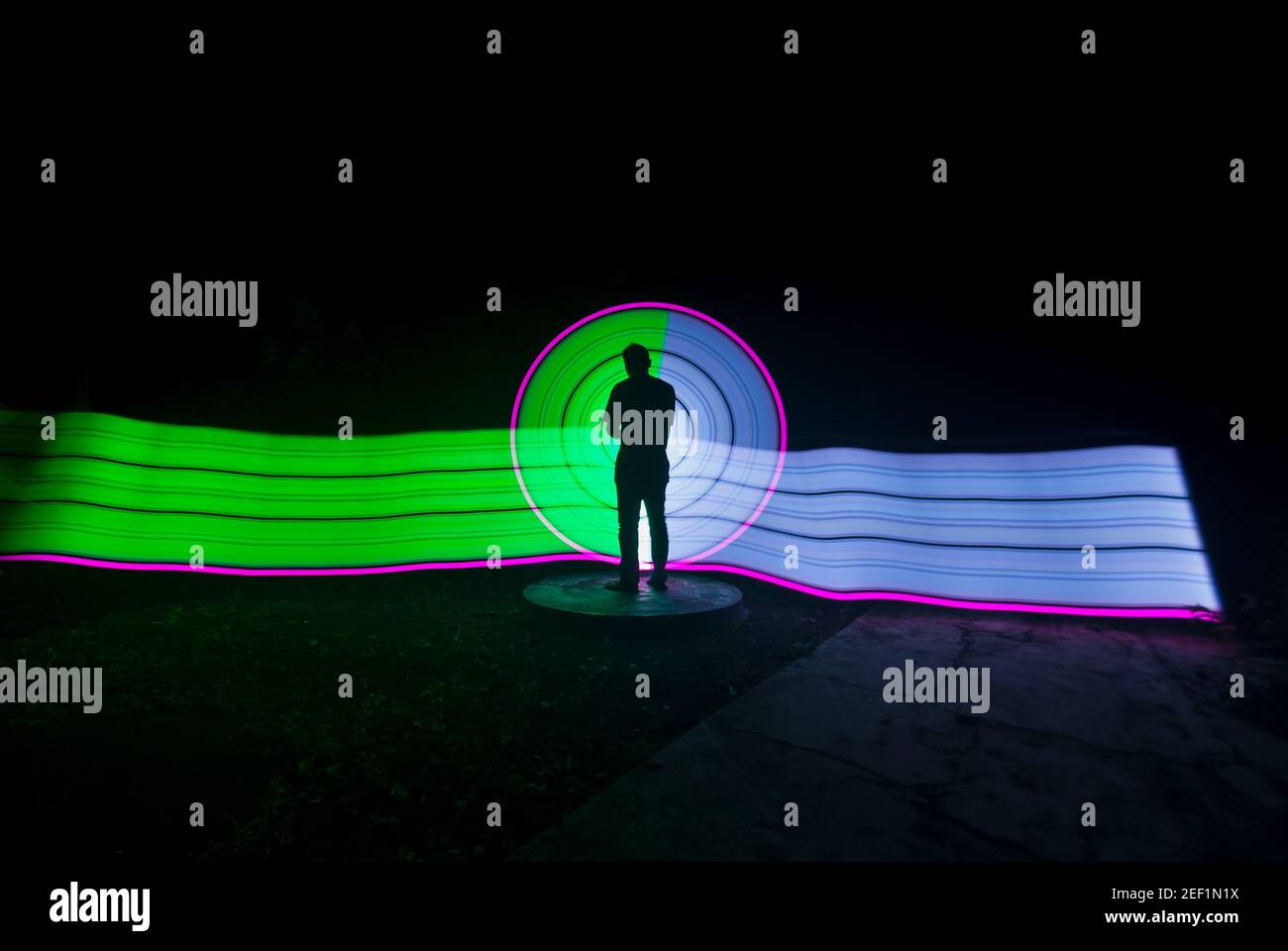 One person standing alone against beautiful color circle LED light ...