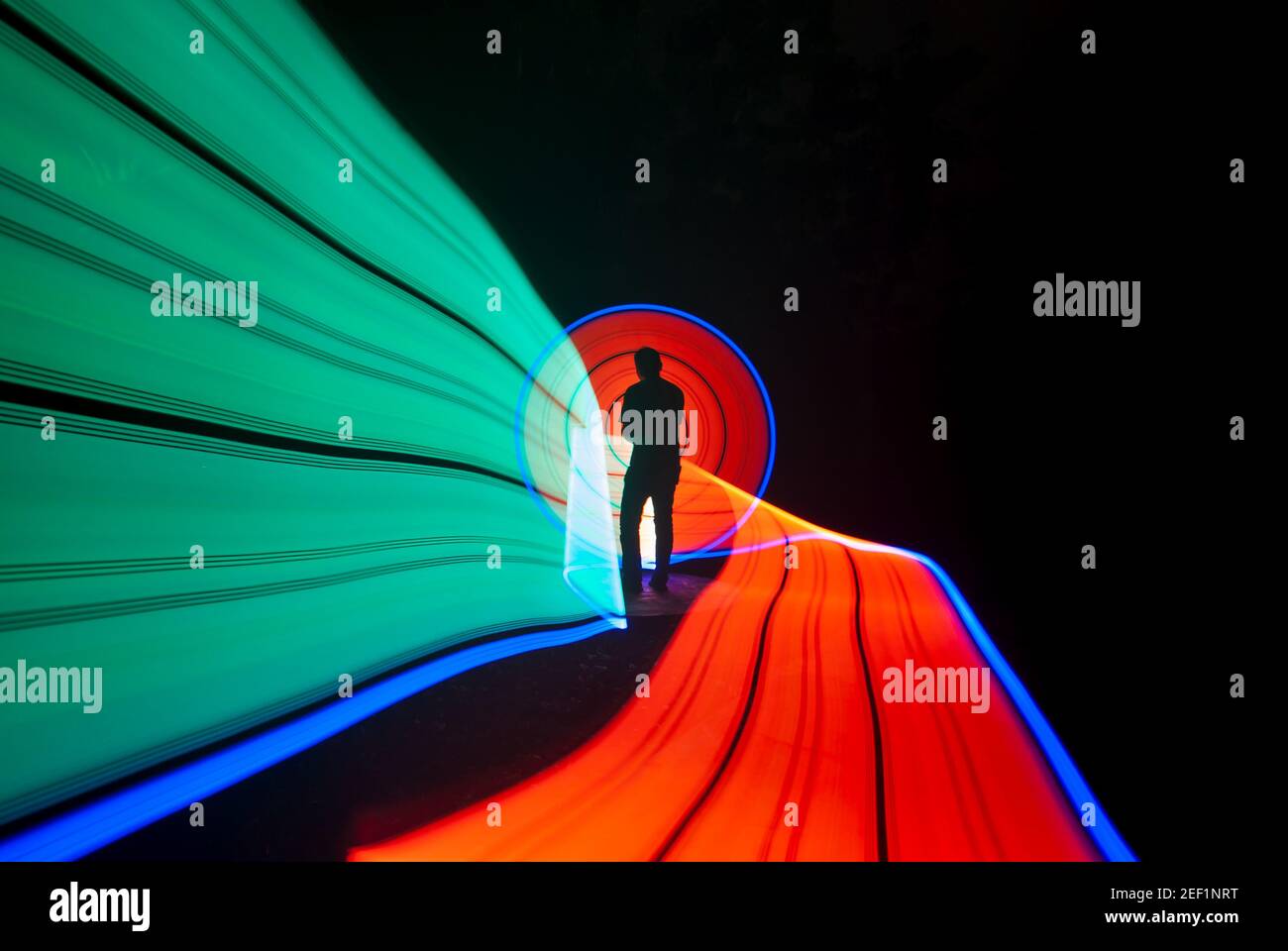 One person standing alone against beautiful color circle LED light ...