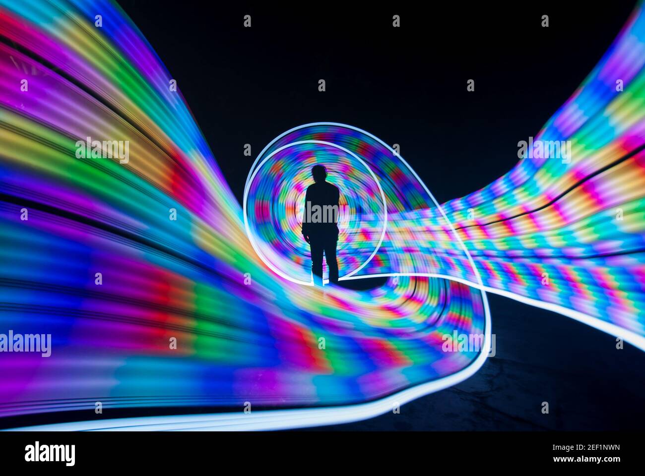 One person standing alone against beautiful color circle LED light ...