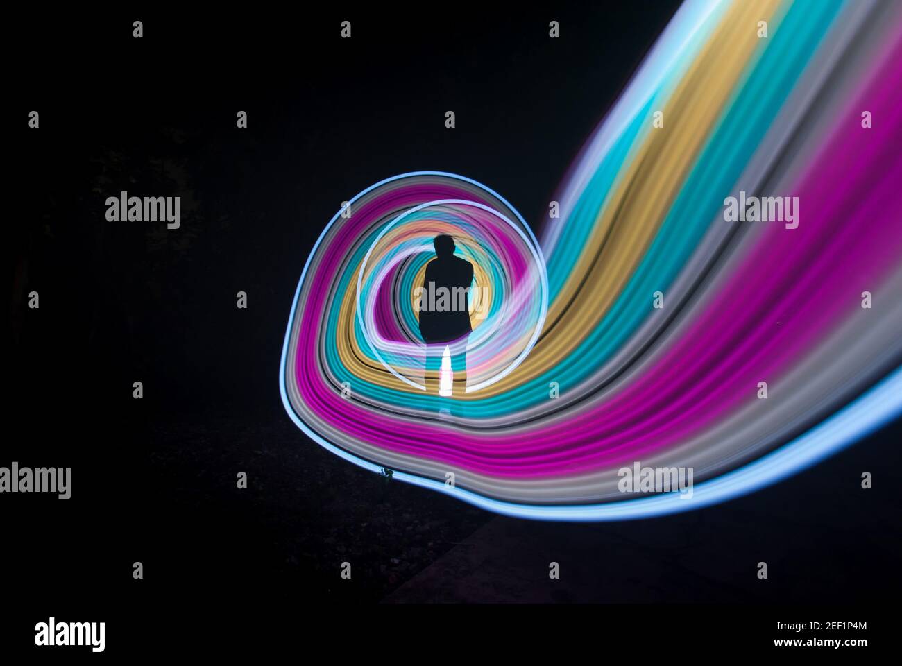 One person standing alone against beautiful color circle LED light ...