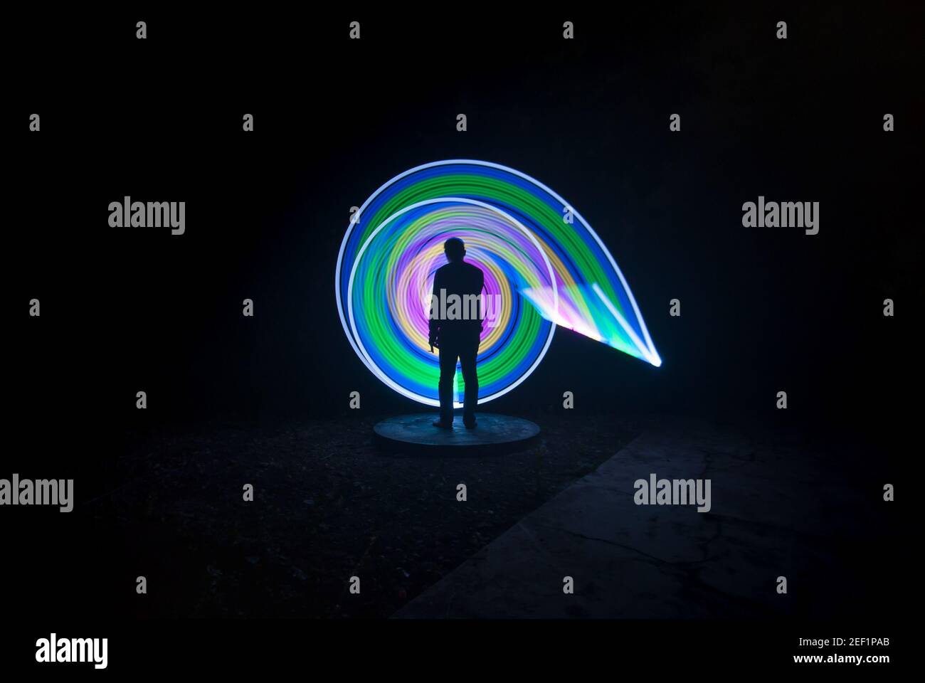 One person standing alone against beautiful color circle LED light ...