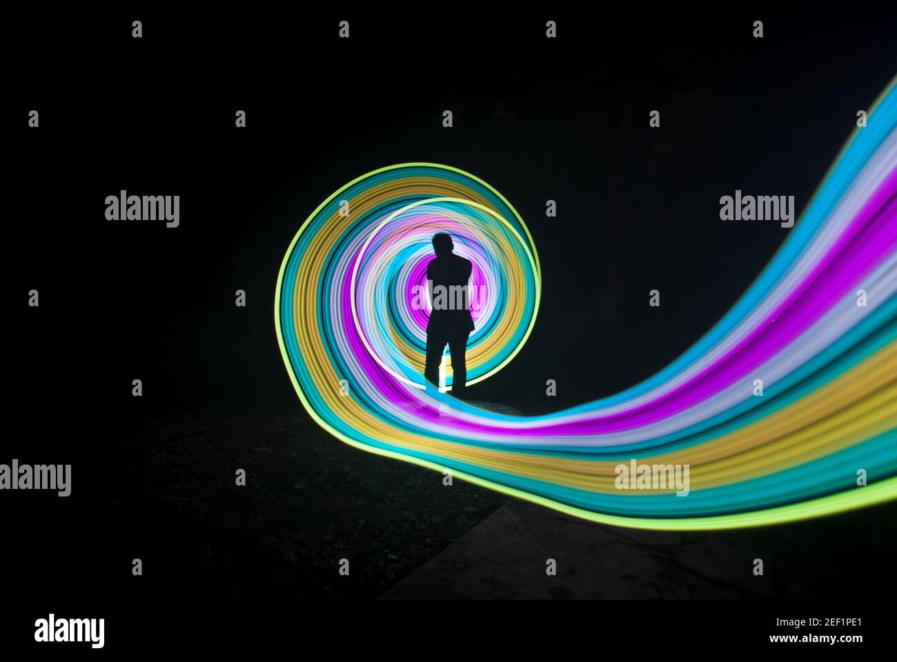 One person standing alone against beautiful color circle LED light ...