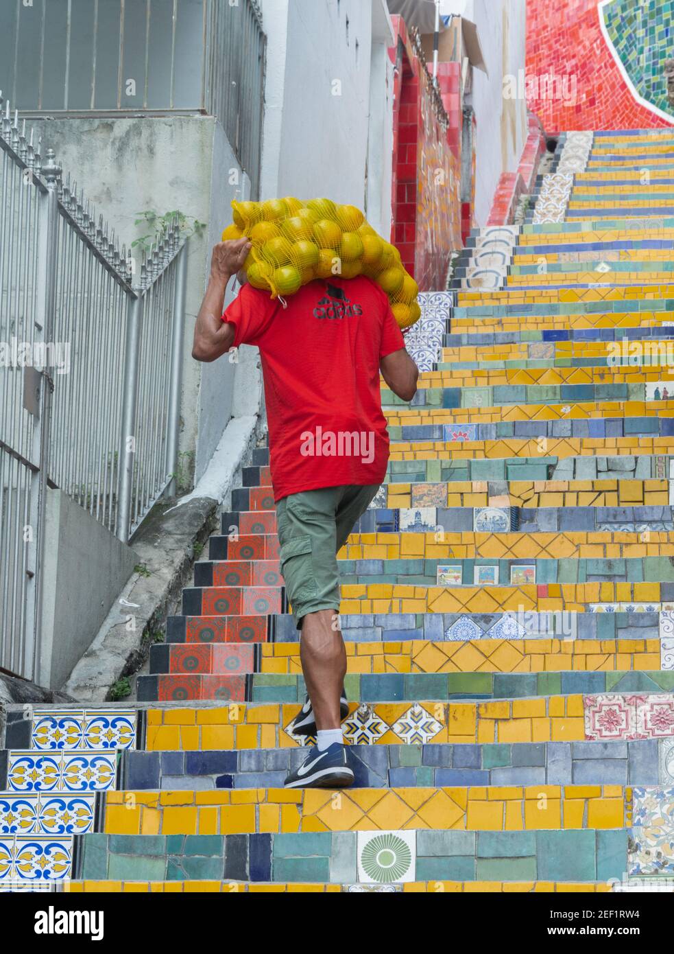 RIO DE JANEIRO, BRAZIL - JANUARY 3, 2020: A worker carries a sack of ...