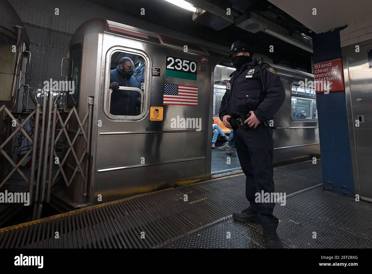 New York, USA. 16th Feb, 2021. An NYPD officer stands near a train ...