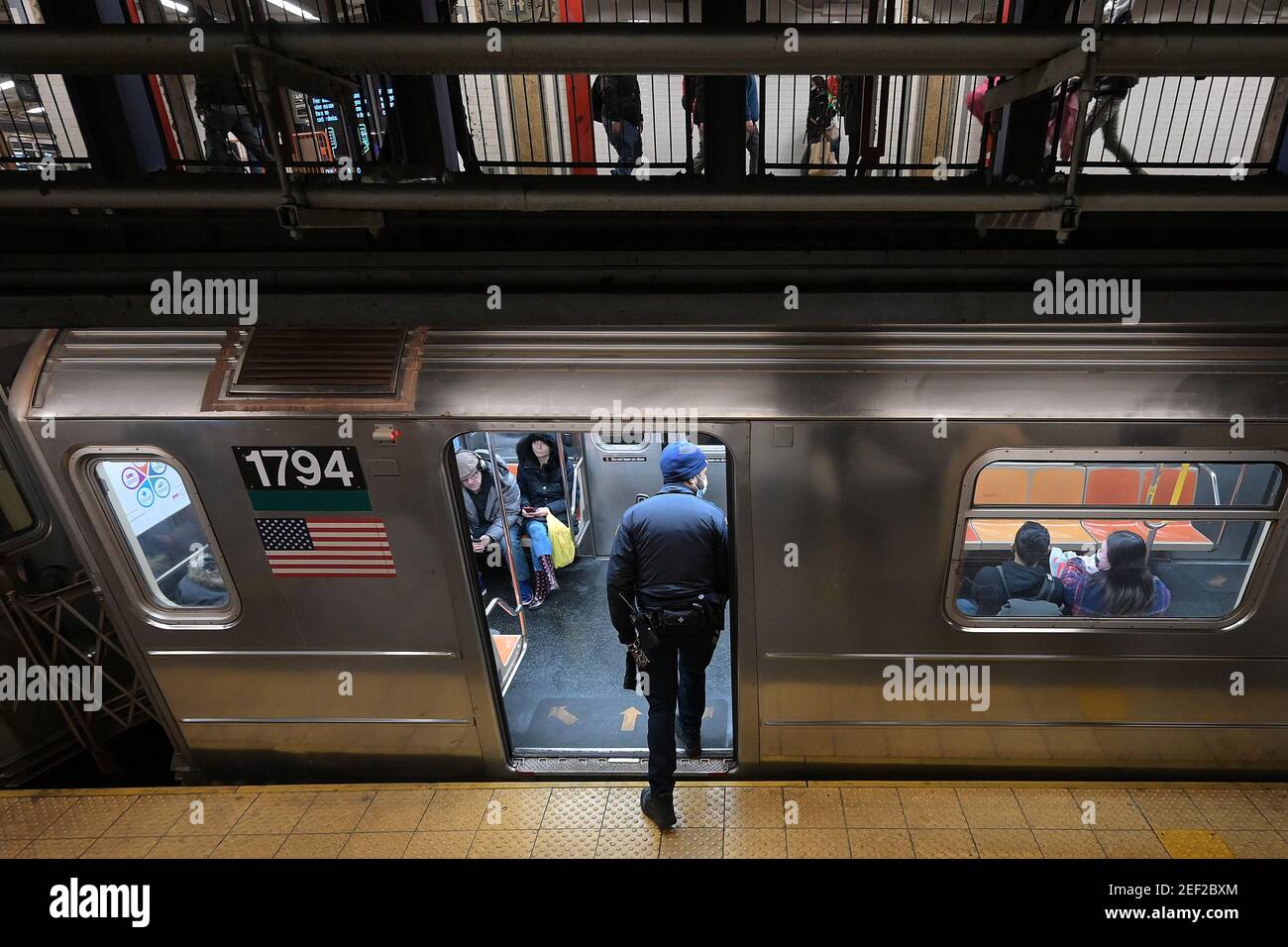 New York, USA. 16th Feb, 2021. An NYPD officer looks into a subway car ...