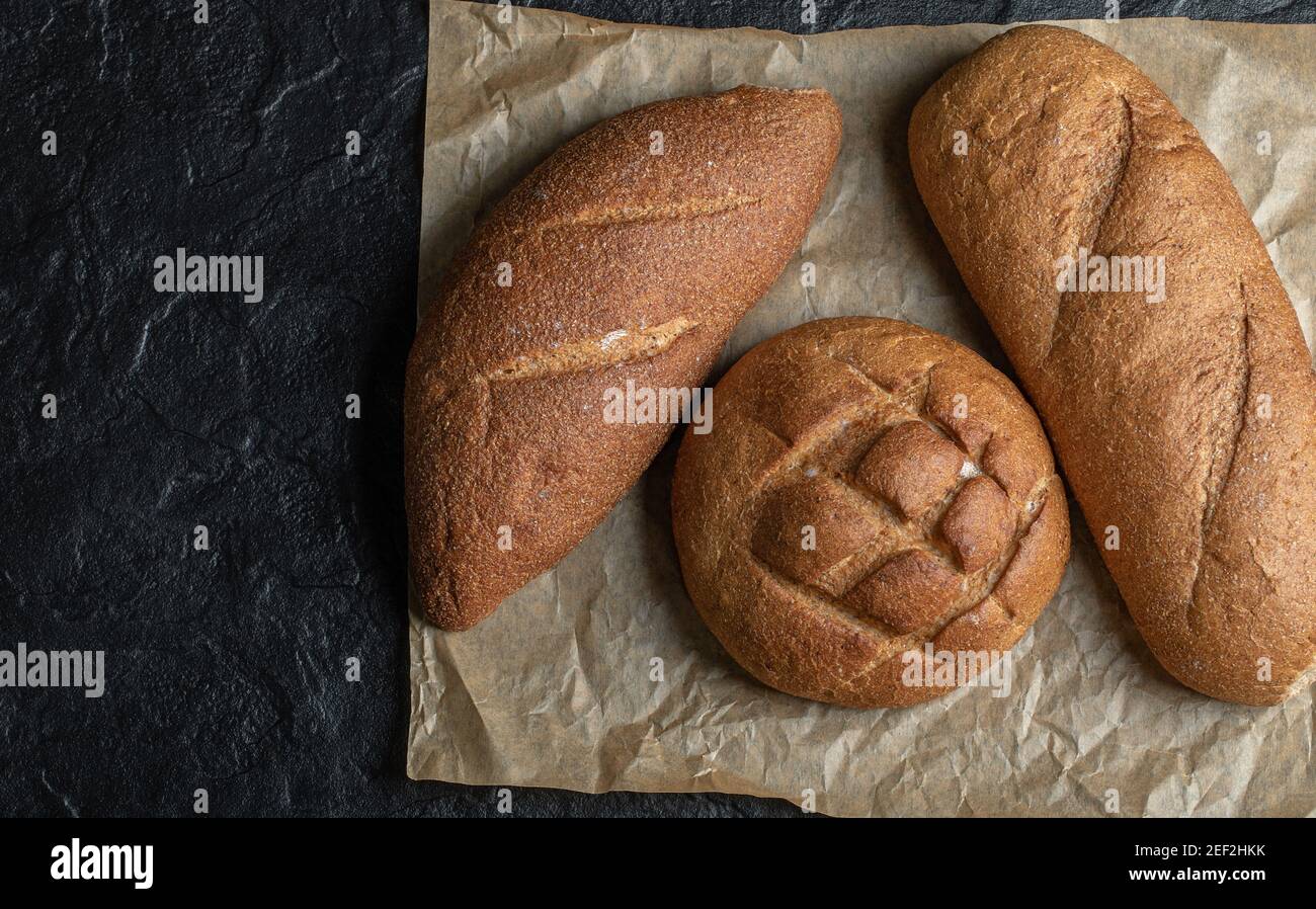 Different shaped loaves bread on black background Stock Photo - Alamy