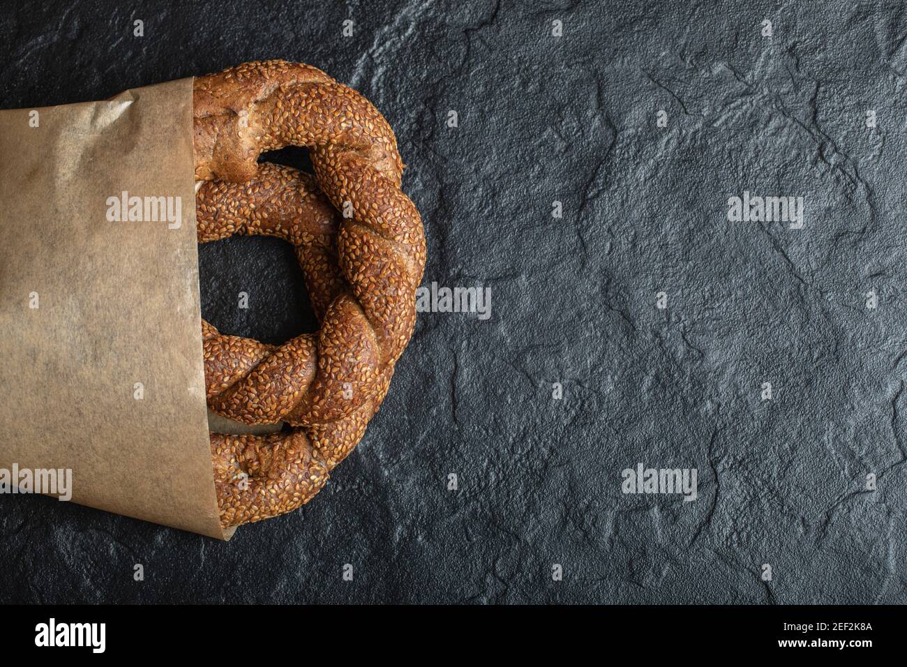 Freshly baked Turkish simit on black background Stock Photo - Alamy