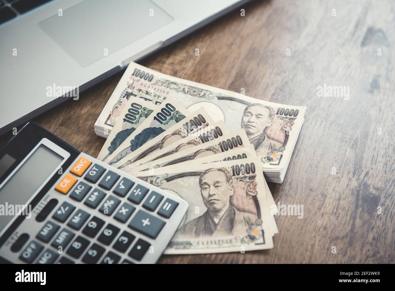 Money, Japanese yen banknotes, and calculator on wood table Stock Photo ...
