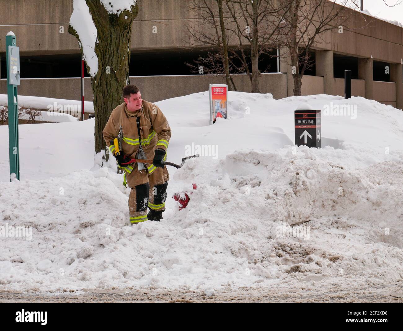 Firefighter digging out fire hydrant covered by heavy snow. Oak Park ...