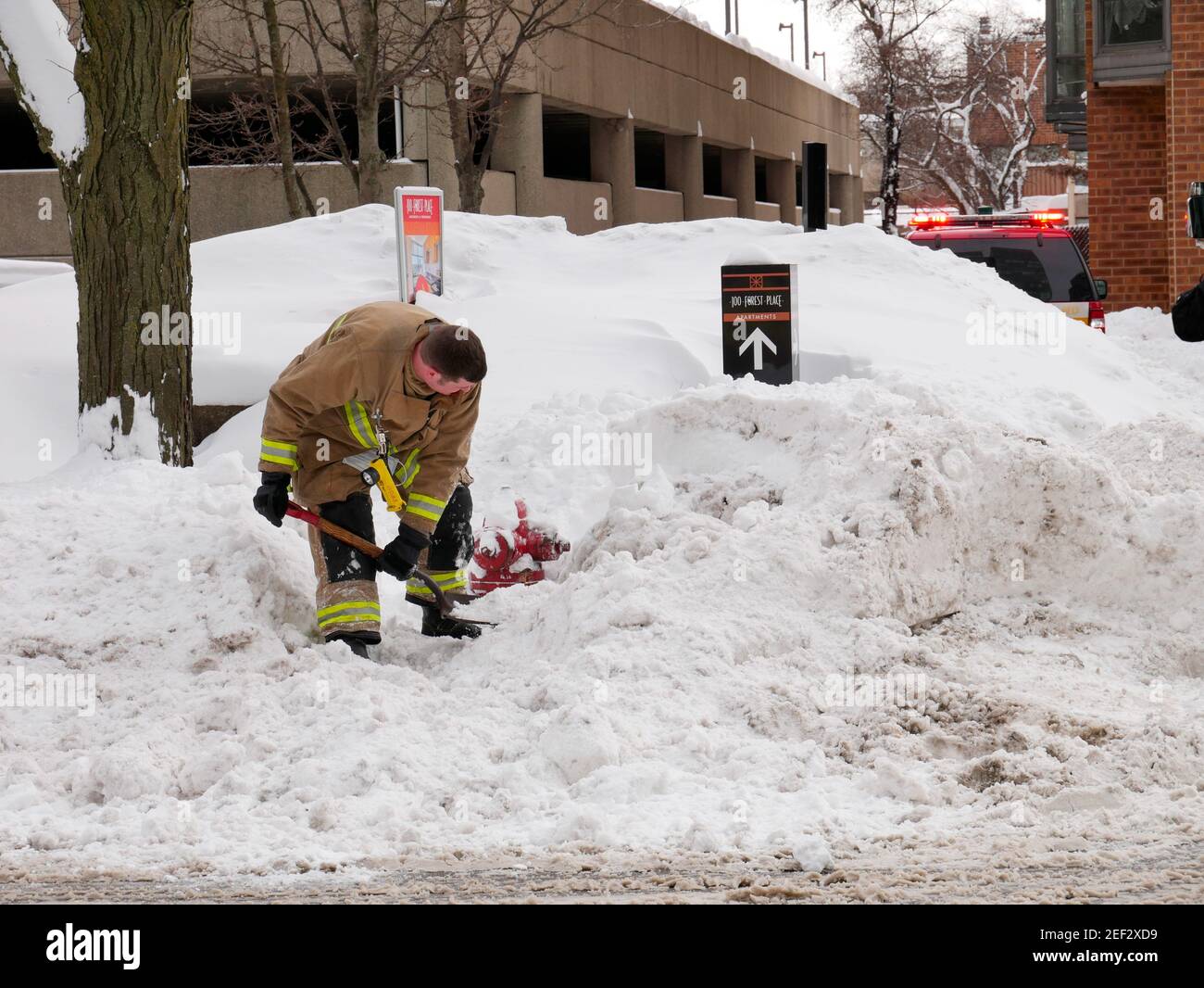 Firefighter digging out fire hydrant covered by heavy snow. Oak Park ...