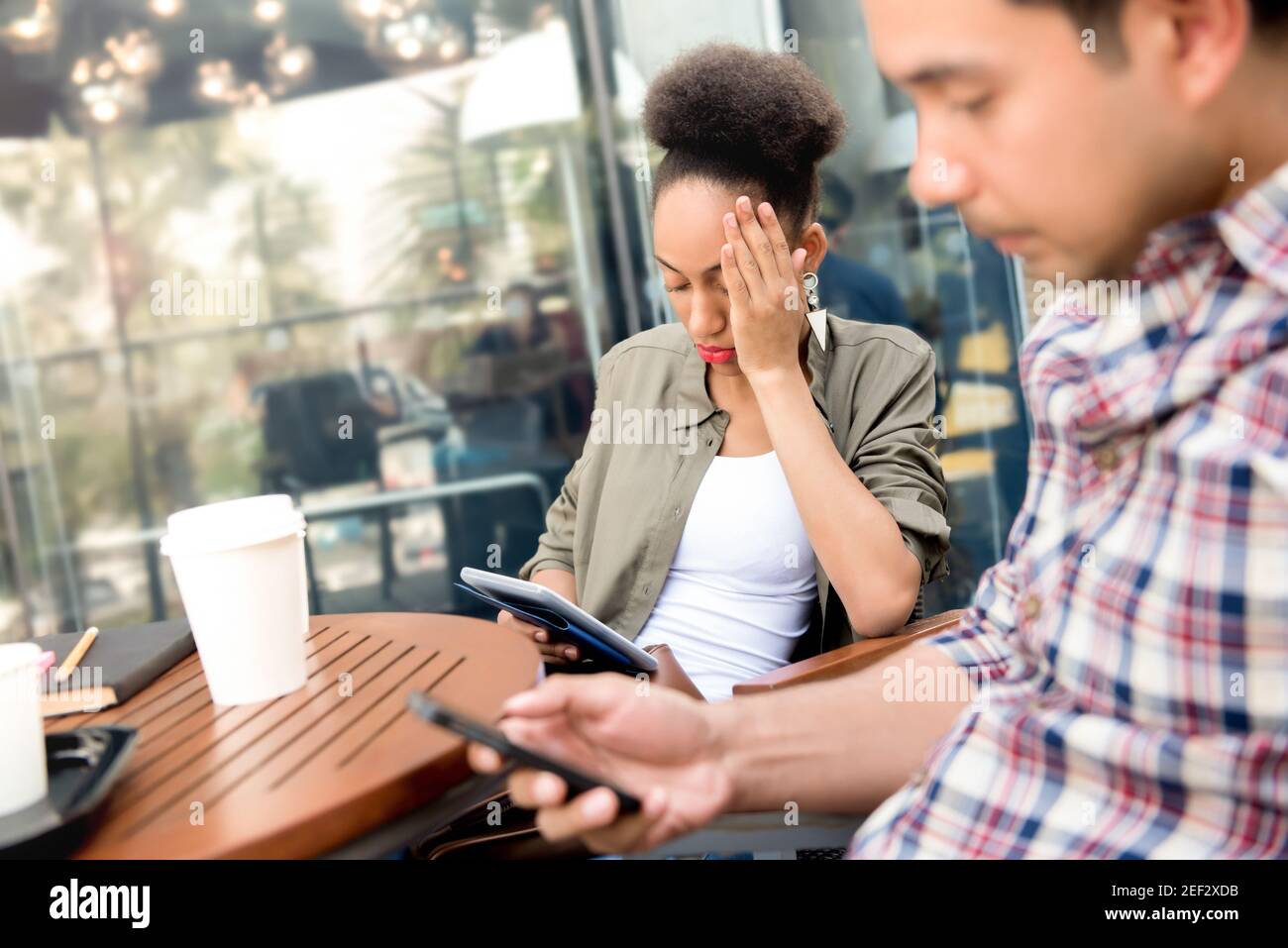 People seriously using smartphone in cafe Stock Photo - Alamy