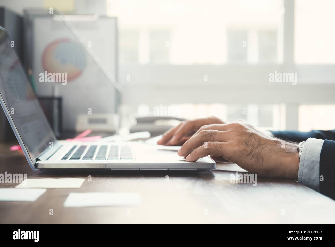 Hands of businessman using laptop computer at working table - side view ...