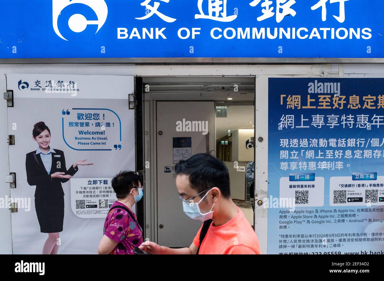 Pedestrians walk past a Chinese Bank of Communications branch in Hong ...