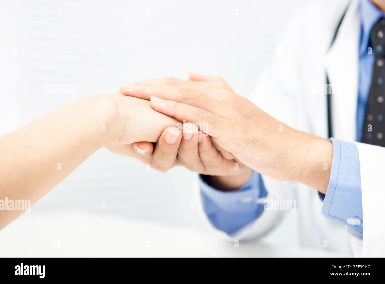 Doctor holding patient hand with care, giving comfort Stock Photo - Alamy