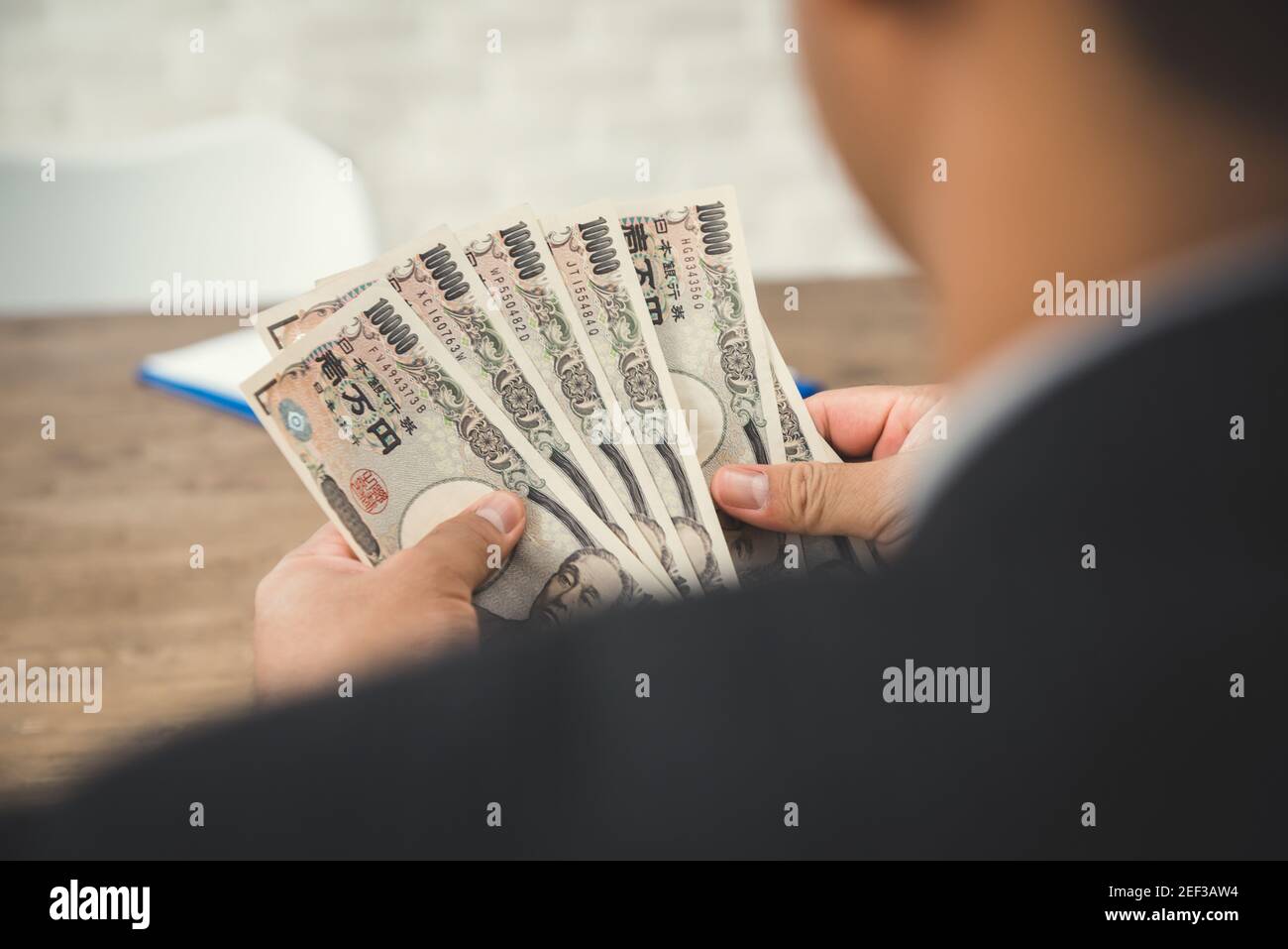 Businessman counting money, Japanese yen banknotes - back view Stock ...