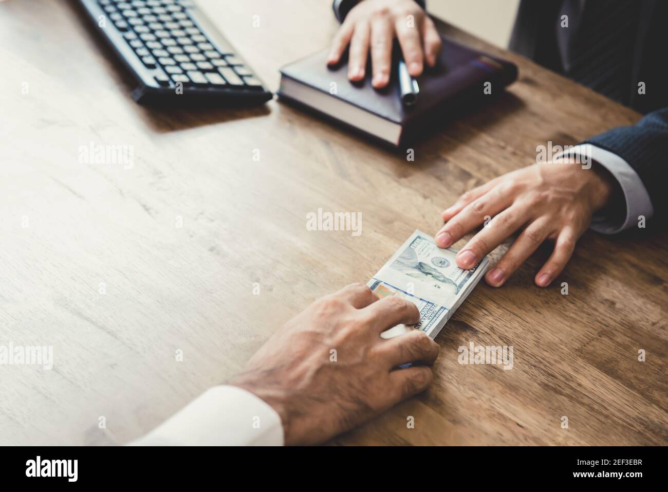 Businessmen passing money on working table - loan, bribery and ...