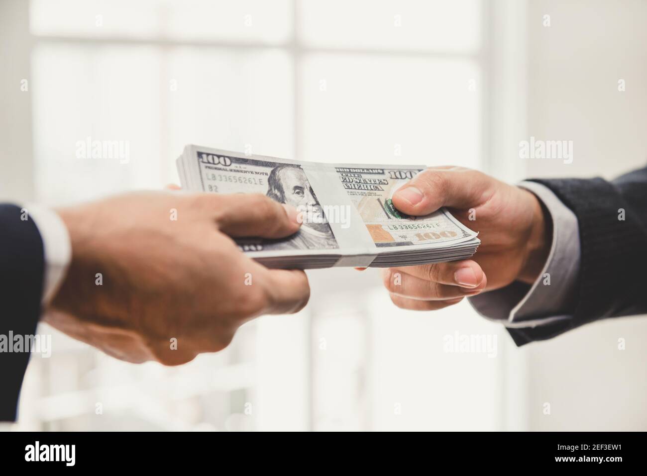 Businessman giving money, US dollar bills, to his partner - loan ...