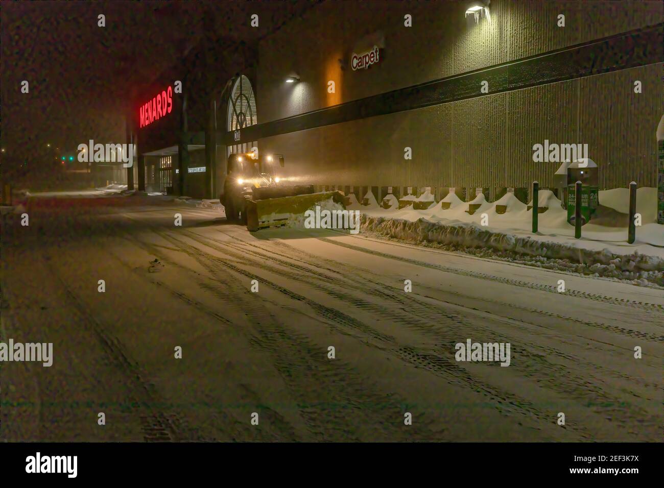 snow removal during heavy snowfall at night in front of the department ...
