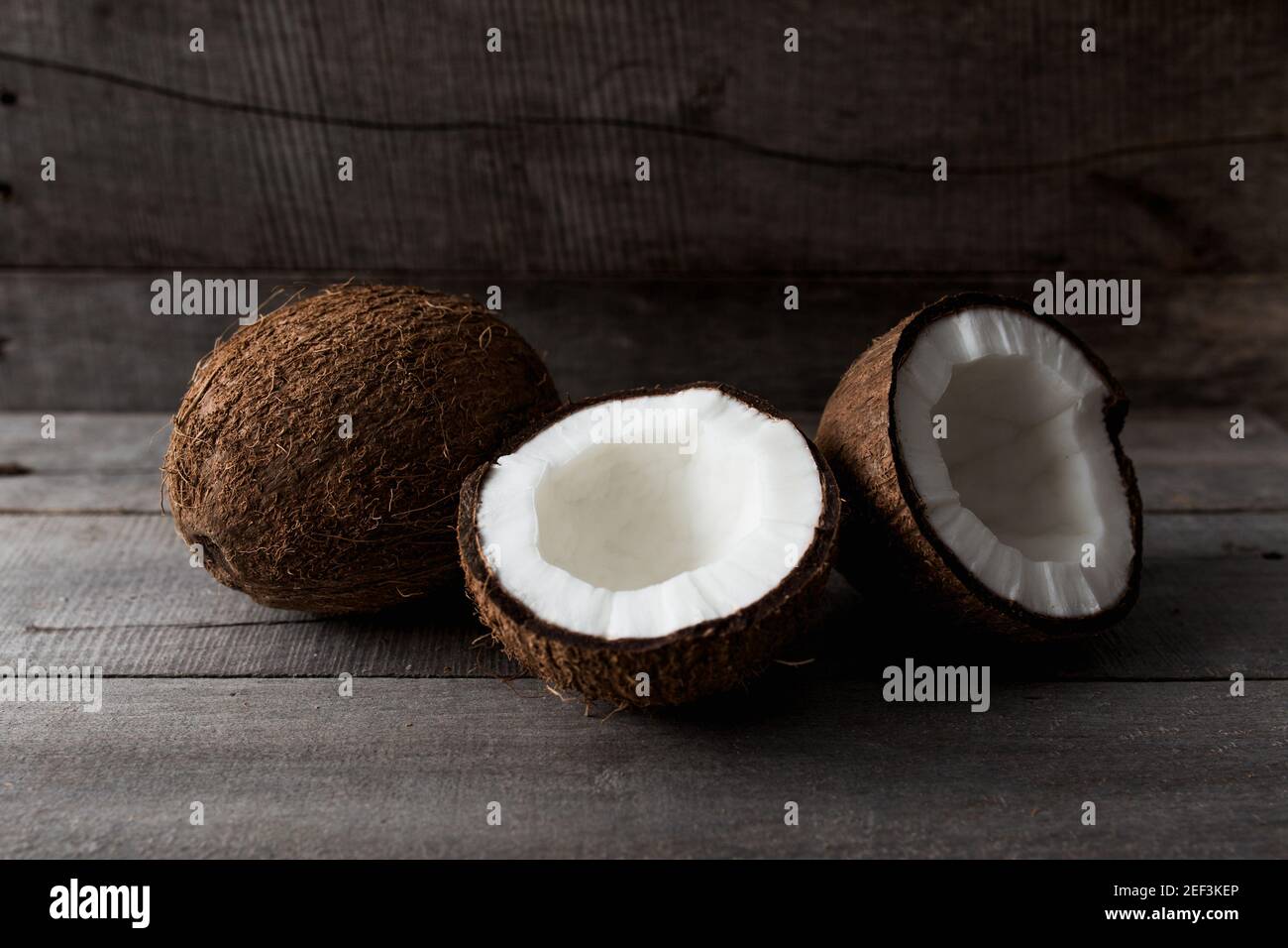 Broken coconuts on gray wooden background. White coconut pulp. High ...