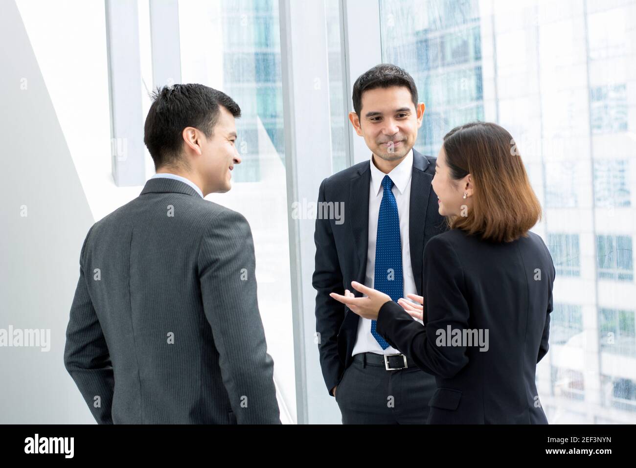 Group of business people talking in building hallway during break at ...