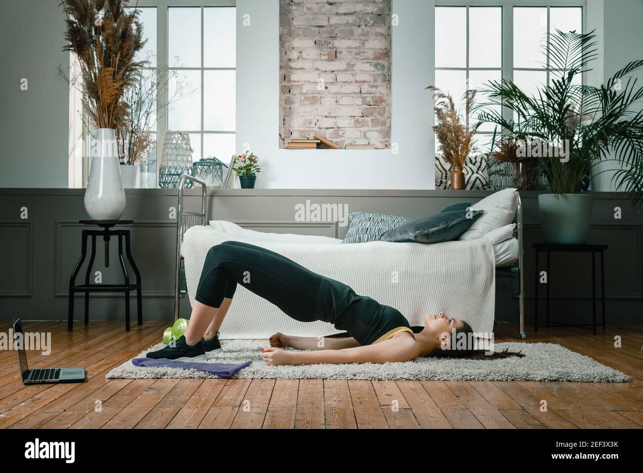 A young woman goes in for sports at home, online workout . The athlete ...