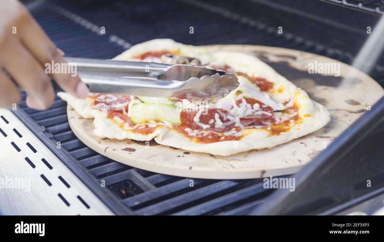 Cooking pizza on outdoor gas grill Stock Photo - Alamy