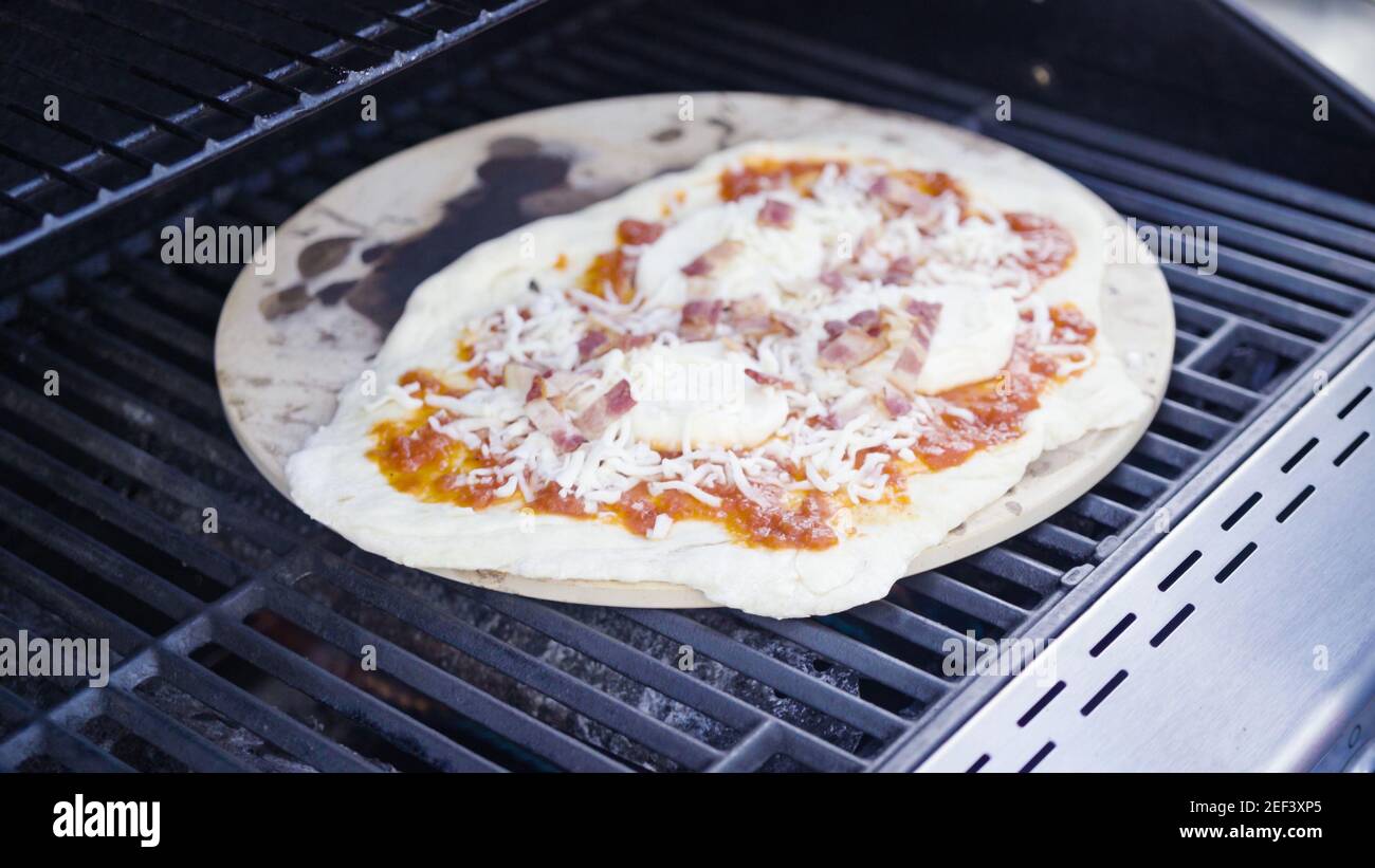 Cooking pizza on outdoor gas grill Stock Photo - Alamy