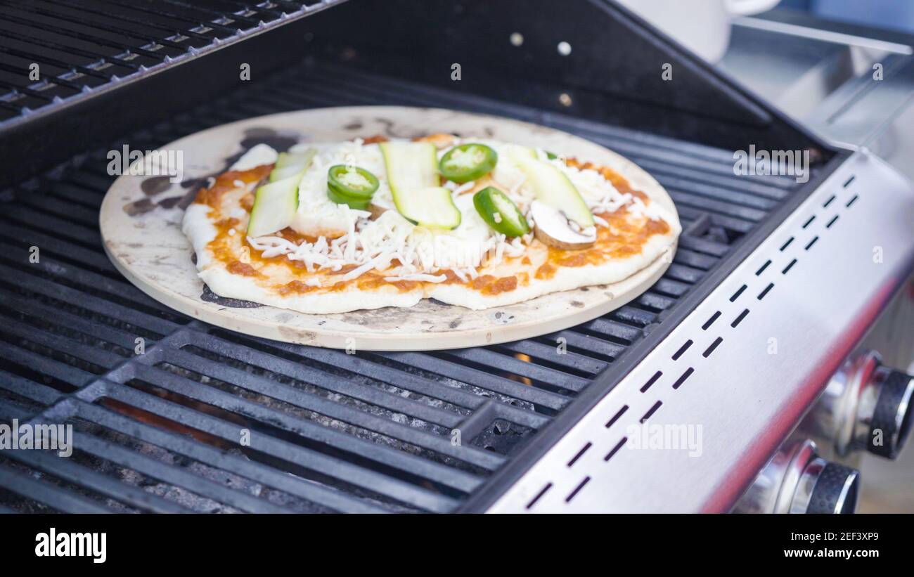 Cooking pizza on outdoor gas grill Stock Photo - Alamy