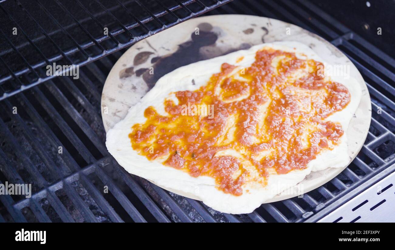 Cooking pizza on outdoor gas grill Stock Photo - Alamy