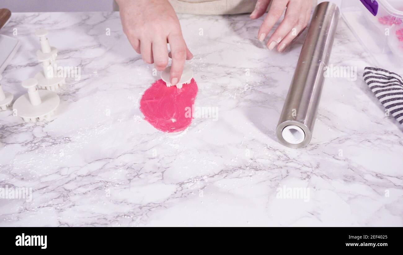 Step by step. Cutting out snowflakes with cookie cutters out of pink ...