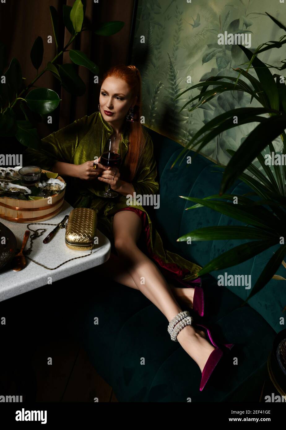 Gorgeous rich red-haired woman vamp has a good time in seafood ...